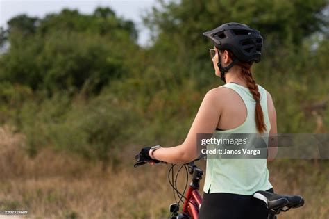 Female Cyclist Looking At Nature During Outdoor Ride High Res Stock