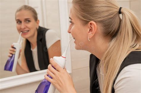 A Woman With Braces On Her Teeth Uses An Irrigator Close Up Portrait