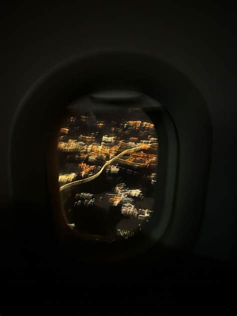 Окно самолёта с видом на ночную Москву