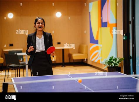 A Young Indian Asian Woman In A Suit Smiles And Laughs As She Plays