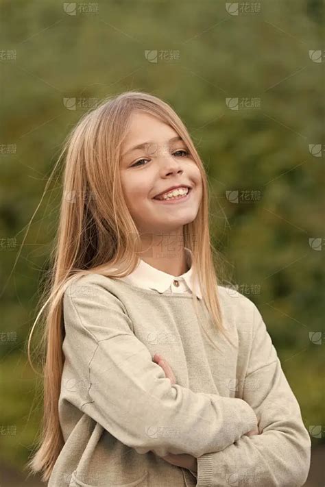 脸上挂着可爱笑容的孩子。一个金发小女孩。漂亮的孩子容光焕发皮肤清新美容美发护肤。快乐的童年和儿 花瓣网