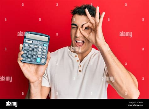 Handsome Young Man Showing Calculator Device Pointing Thumb Up To The Side Smiling Happy With