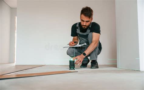 Laser Leveler Device Man Is Installing New Laminated Wooden Floor