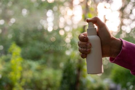 Person Spraying Insect Repellent At Her Hand Outdoors During Summer