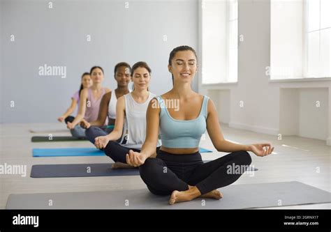 Group Of Happy Relaxed Women Having Yoga Class At Gym Doing Lotus Pose