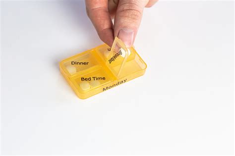 알 약 알림 상자와 인간의 손 흰색 배경에 고립 된 약물을 복용 월요일 알 약 주최자 상자 복용량에 대한 스톡 사진 및 기타