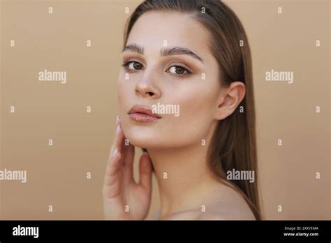 Beautiful Young Brunette Woman With Clean Fresh Skin Touching Own Face