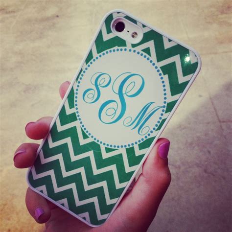 A Womans Hand Holding An Iphone Case With A Monogrammed Design On It