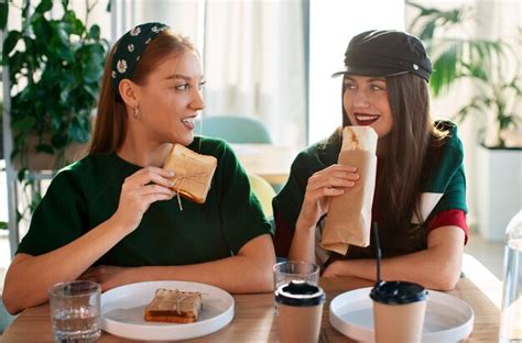 Free Photo Front View Women Holding Paper Wrapped Sandwich