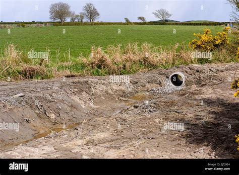 A Drainage Ditch Is Dug In A Field With A Small Culvert Pipe To Drain