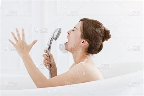 年轻女子在浴缸里一边洗澡一边唱歌
