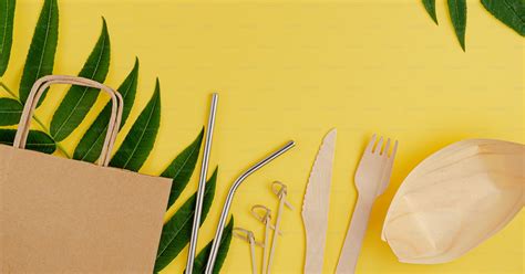 노란색 배경에 대나무 종이 일회용 식기 및 금속 빨대가 있는 친환경 세트 복사 공간 플랫 레이 사진 Unsplash의