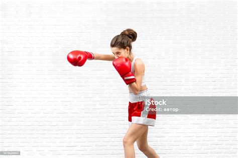 빨간 권투 장갑과 복서 반바지를 입은 매력적인 백인 젊은 여성이 로프트 흰색 배경에 펀치를 연습합니다 복싱 여자에 대한 스톡