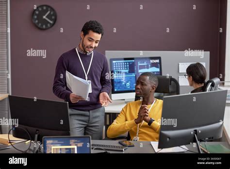 Portrait Of Two Business Analytics Discussing Project In High Tech It