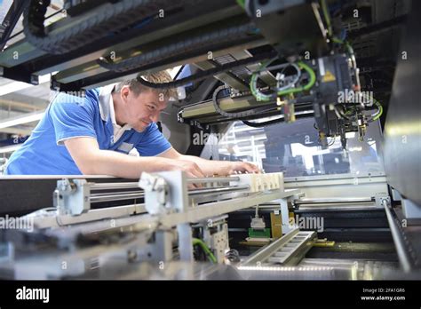Engineer Working On A Machine For Assembly And Production Of Semiconductor Boards In An Engineer Working On A Machine For Assembly And Production Of Semiconductor Boards In An