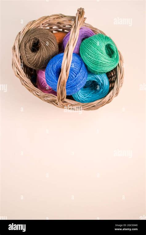 A Pile Of Colorful Textile Balls Of Wool In A Wicker Basket On Brown