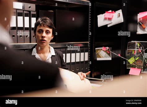 Police Officer Discussing Missing Person Case With Detective Working