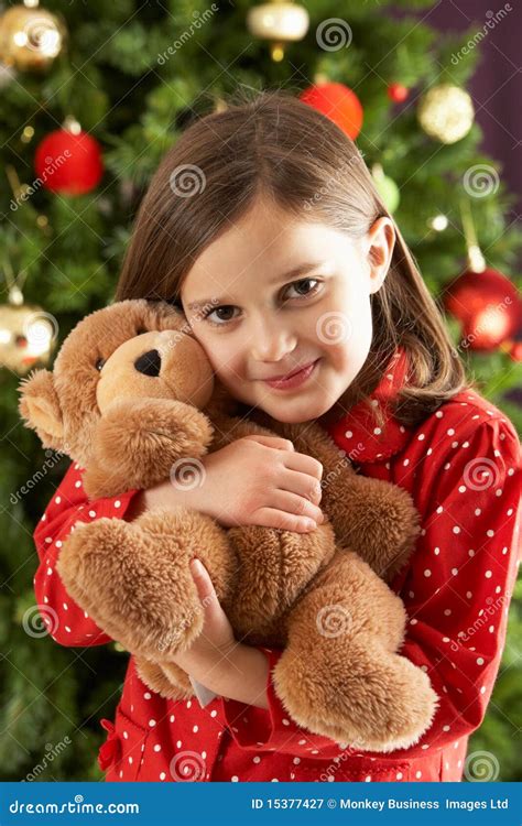 Girl Cuddling Bear In Front Of Christmas Tree Stock Image Image Of