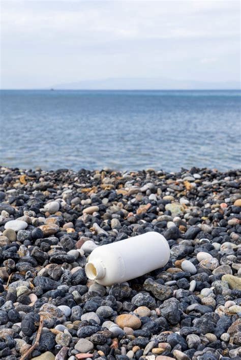 Vertical Shot Of An Empty Plastic Bottle On A Pebble Beach The Concept