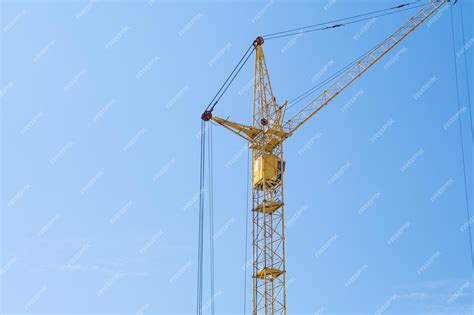 Premium Photo Crane And A Building Under Construction Against A Blue Sky Background
