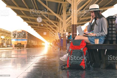 젊은 여자 프리랜서 작업 노트북 여행 여름 여행 전에 기차역에서 위치를 검색 하기 위한 모바일 사용 하 여 Hipster 여행 역의 플랫폼에서 기차를 기다리고 있습니다