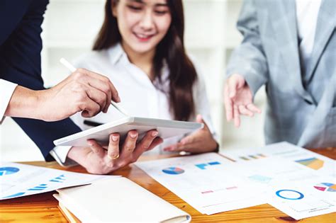 투자 위험을 줄이기위한 계획 파트너와 함께 일하는 사업가 그룹의 이미지는 회의에서 수익성 있고 표적화 된 고객 요구를 분석하기위한 마케팅 전략을 조정하고 있습니다 3 명에