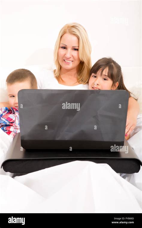 A Mother Using With Her Son And Babe A Laptop Computer In Bed Stock Photo Alamy