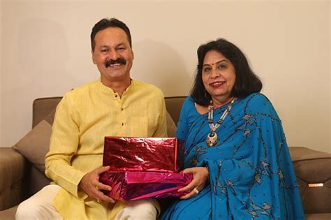 행복한 인도 남자는 사리에서 인도인 아내를 위해 깜짝 선물을 가져옵니다 둘 다 디왈리 축제에 인도 민족 의상을 입고 있습니다 2