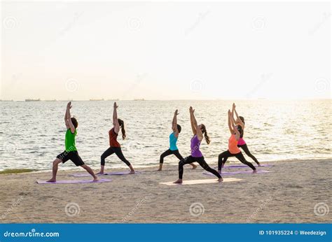 Yoga Class At Sea Beach In Sunset Time Group Of People Doing Wa Stock