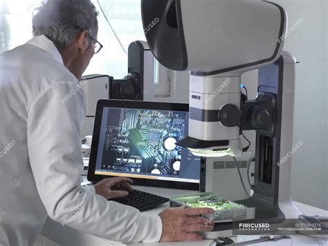Engineer Using Stereo Microscope For Inspecting Printed Circuit Board