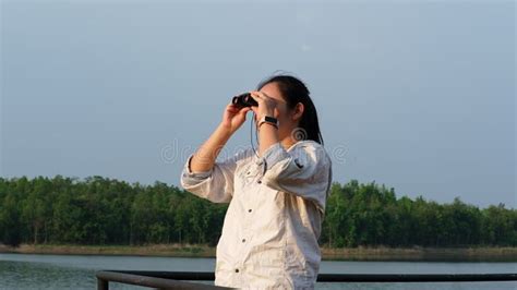 Young Female Explorer With Binoculars Exploring Nature Or Watching