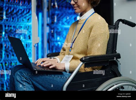 Close Up Of Female Engineer With Disability Sitting In Wheelchair And Typing On Laptop She