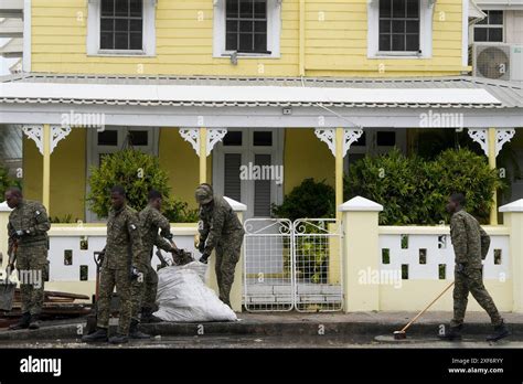 Members Of The Barbados Defence Force Clean Up A Street After Hurricane