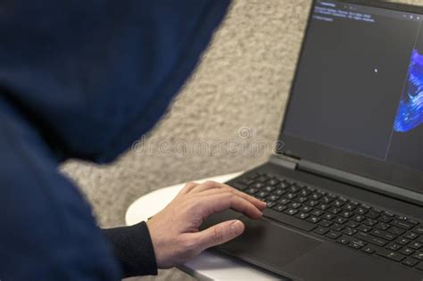 Man Looked Like Hacker In A Hood Sitting In The Front Of Laptop