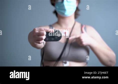 Unrecognizable Woman In Medical Mask Wears Holter Monitor For Daily