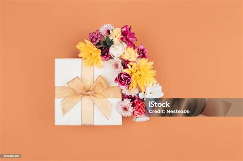 리본으로 감싸인 아름다운 흰색 상자 옆에 다양한 꽃 상자 뚜껑에 아름다운 활 오렌지 색 배경에 3 월 8 일 선물의 혼합 0명에
