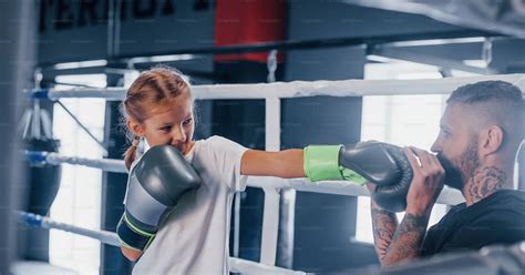 권투 링에서 서로 스파링을합니다 젊은 문신을 한 권투 코치는 체육관에서 귀여운 소녀를 가르칩니다 사진 Unsplash의