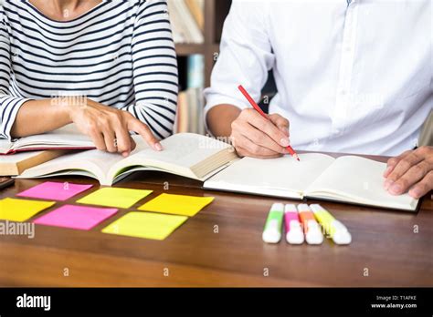 Young Students Classmates Help Friend Catching Up Workbook And Learning