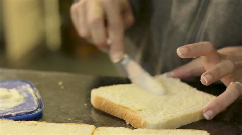 Premium Stock Video Young Woman Busy Buttering Bread To Make