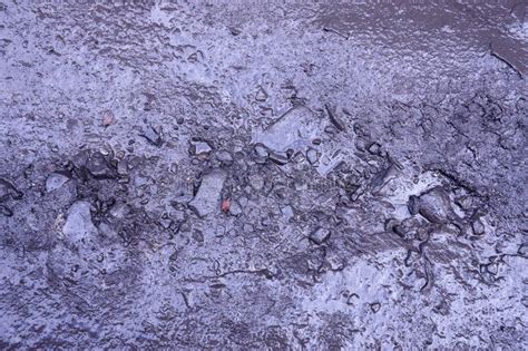 Close Up Of Muddy Puddle With Small Stones On Wet Surface Background Texture With Top View