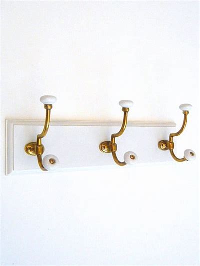 Klassisk Knagerække M 3 Franske Brunerede Messingknager M Hvide Porcelænsknopper På Hvidt