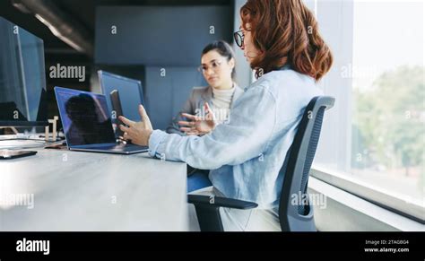 Female Colleagues Actively Collaborate In A Modern Office Engaging In