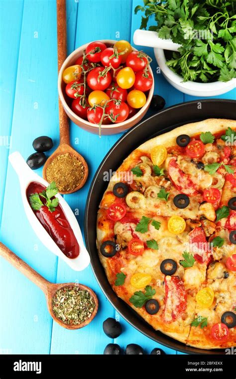 Colorful Composition Of Delicious Pizza Vegetables And Spices On Blue