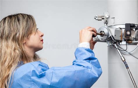 Young Female Scientist Loading A Specimen Using A Sample Holder Into A Transmission Electron