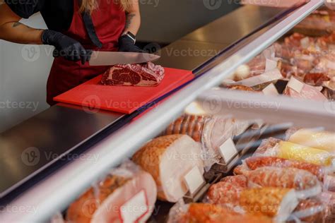 A Skilled Butcher Engaged In The Art Of Preparing Fresh Cuts Of Meat At