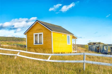 Abandoned Yellow Small House With White Fence In Countryside Stock