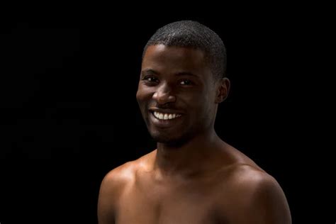 Naked African Man Toothy Smiles Looking Up On Black Background