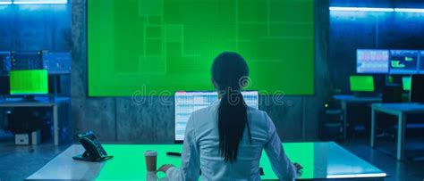 Computer Monitors Show A Green Screen Mock Up Of A Female Software Engineer Working In A Modern