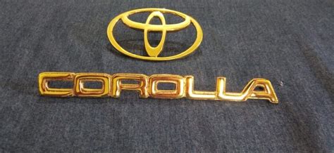Toyota Logo And Corolla Emblem In Gold Metal