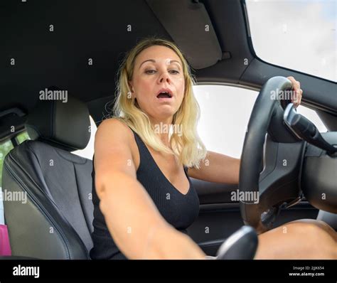 Distracted Female Driver Using Her Mobile Phone While Driving Reading A Text Message With Her